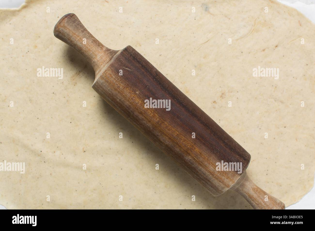 Overhead view of rolled out crackers dough on parchment paper, cracker ...