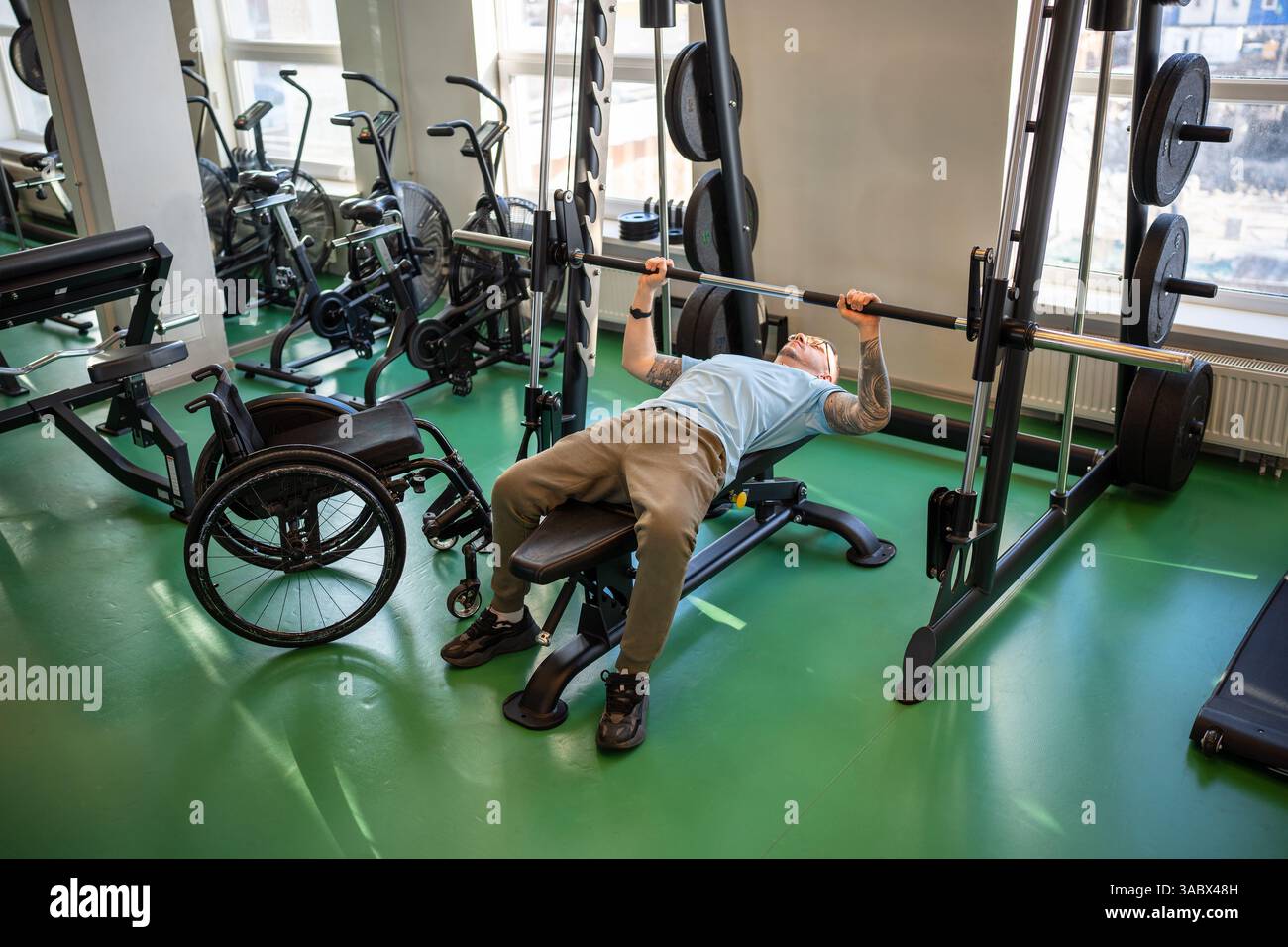 Disabled athlete strengthens body by lifting barbell in gym, healthy ...