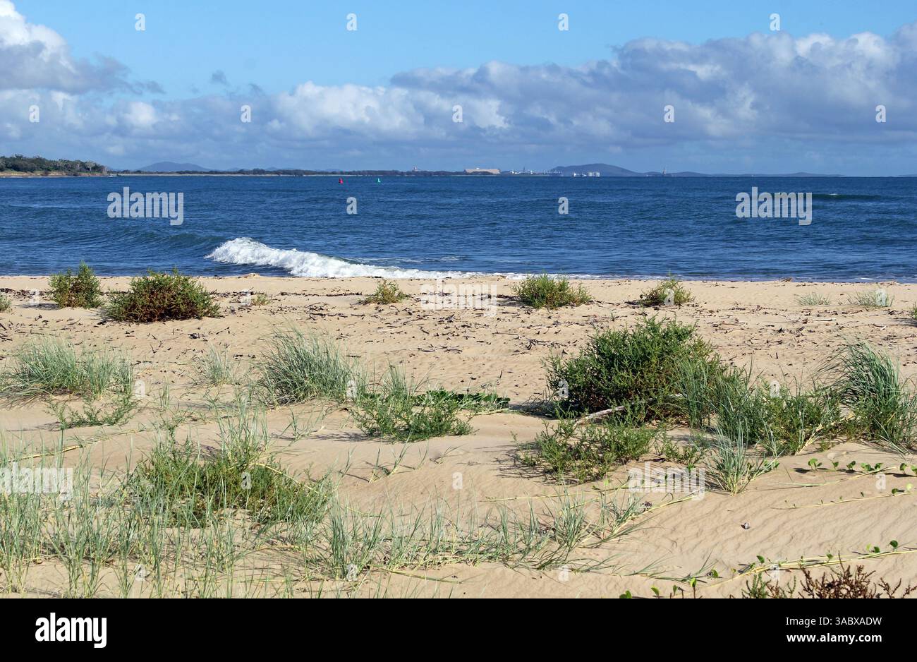 Canoe Point beach with ocean waves, sand and vegetation at Tannum Sands ...