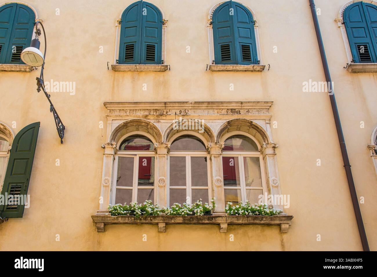 Elegant arched windows in an historic building in Udine, Italy. Triple ...