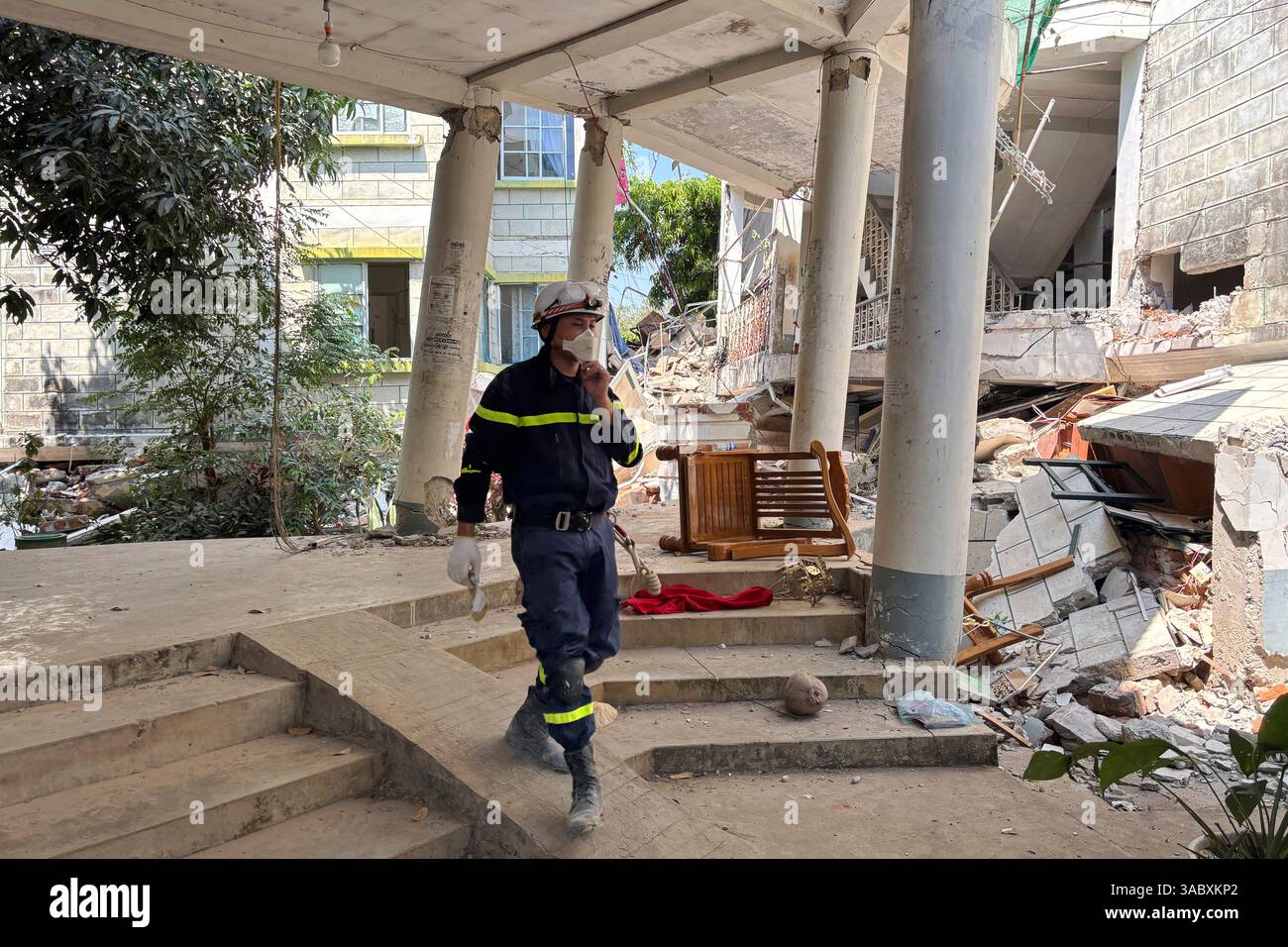 A Vietnamese rescuer works through the rubble of a collapsed building ...
