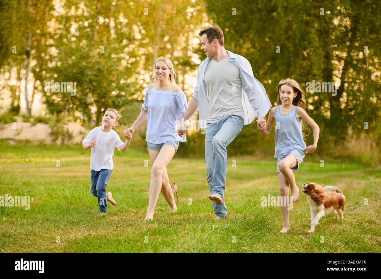 Mom, dad, boy, girl enjoy country rest holding hands, running barefoot ...