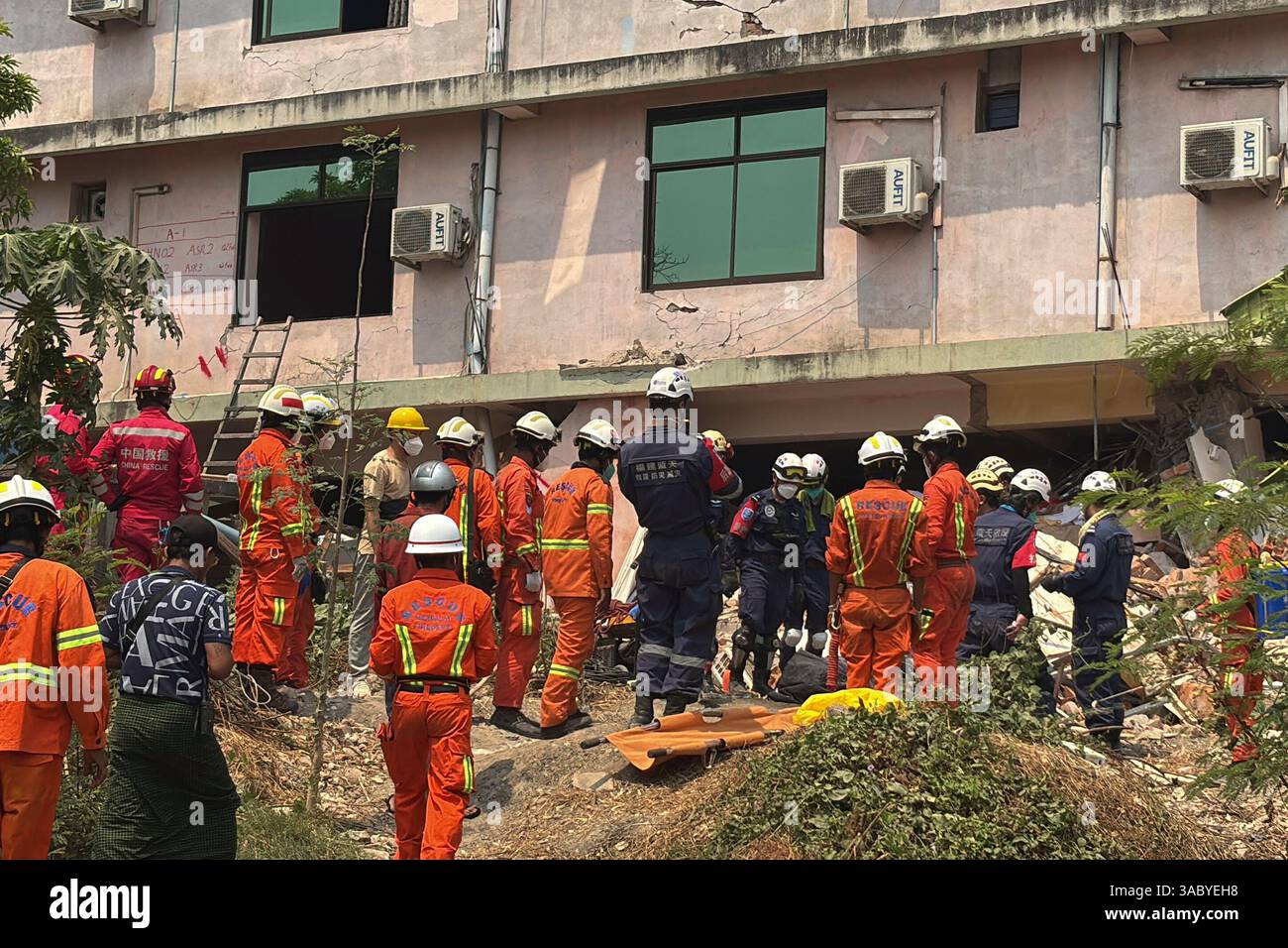 Rescuers carry the body of a victim, from a collapsed building in the ...