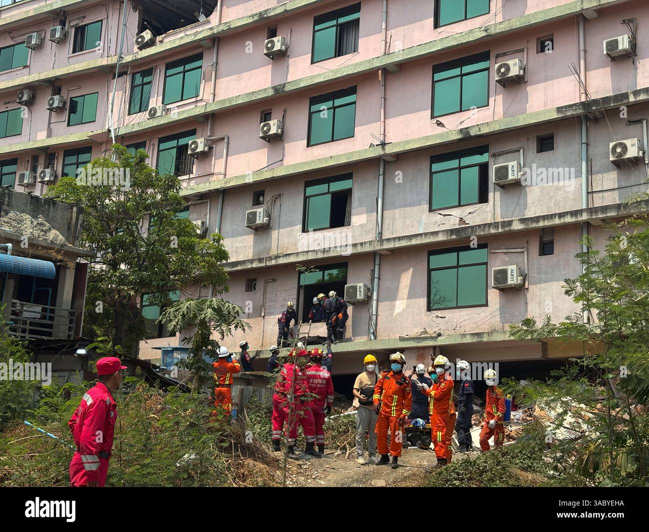 Rescuers carry the body of a victim, from a collapsed building in the ...