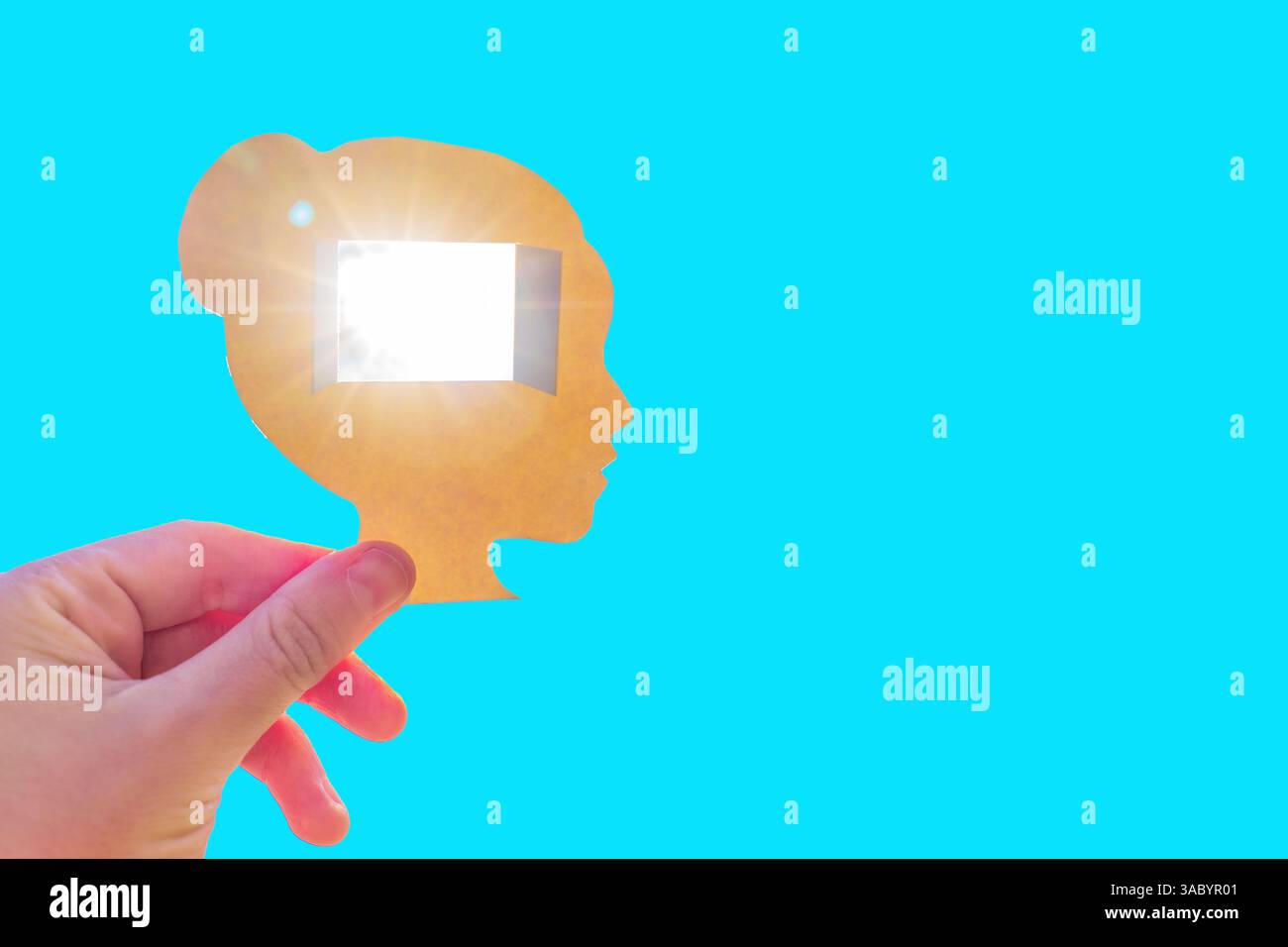 Hand holding a paper cutout of a woman's head in profile, with shutters ...