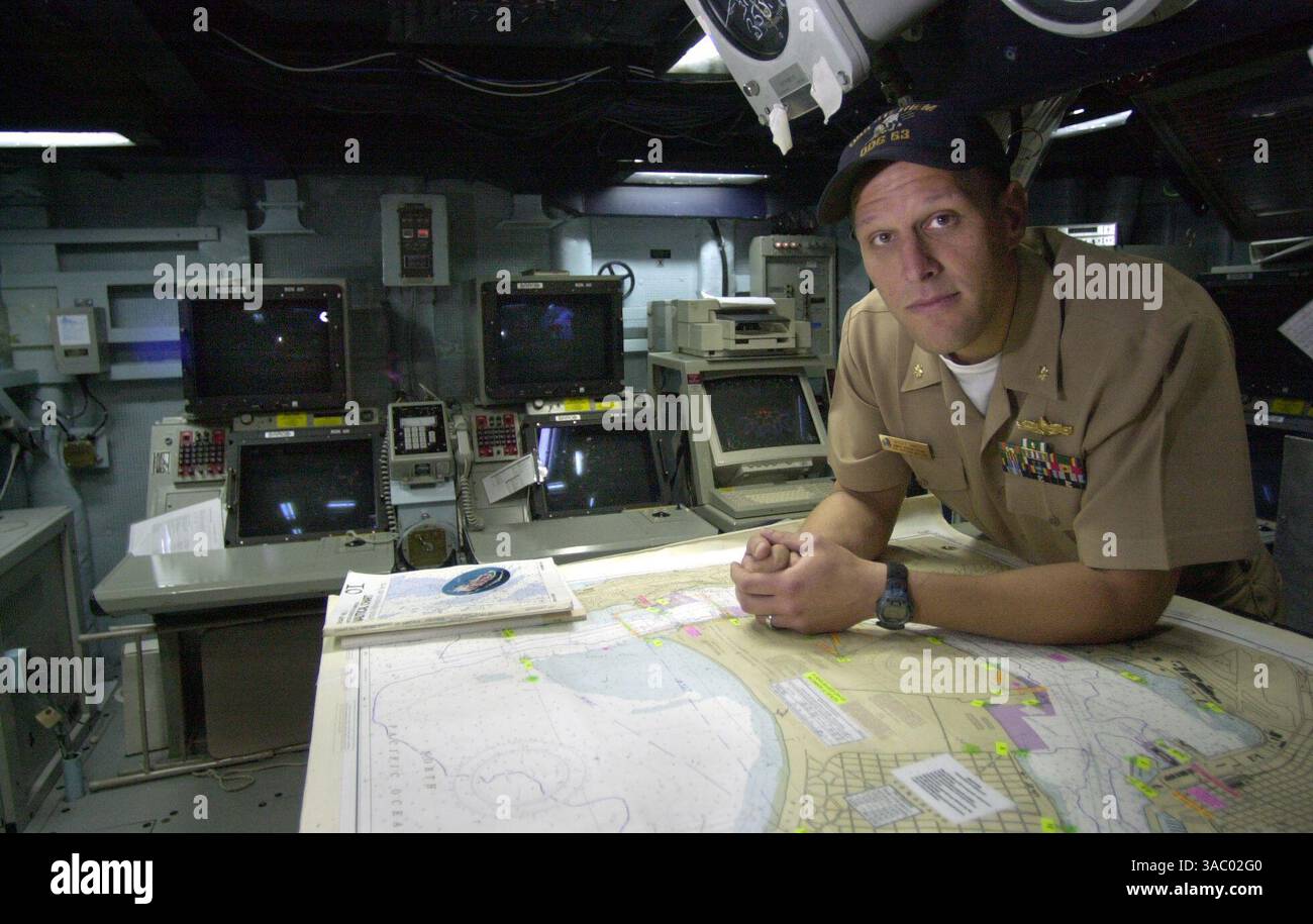 (PUBLISHED 04/13/2003, B-1): Navy Commander Scott Smith stands over a ...