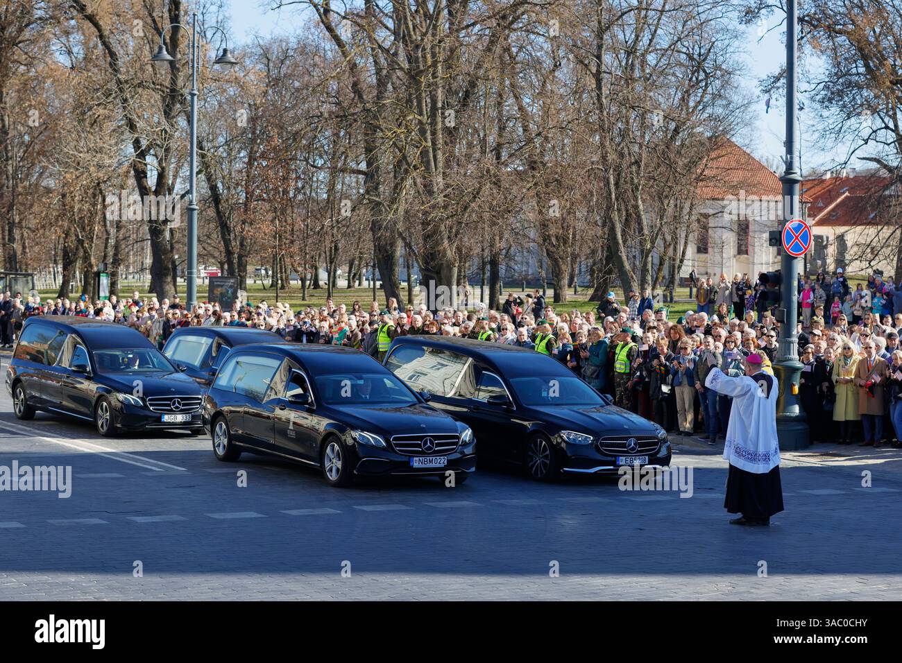 A Catholic priest makes a service in front of a motorcade of ...