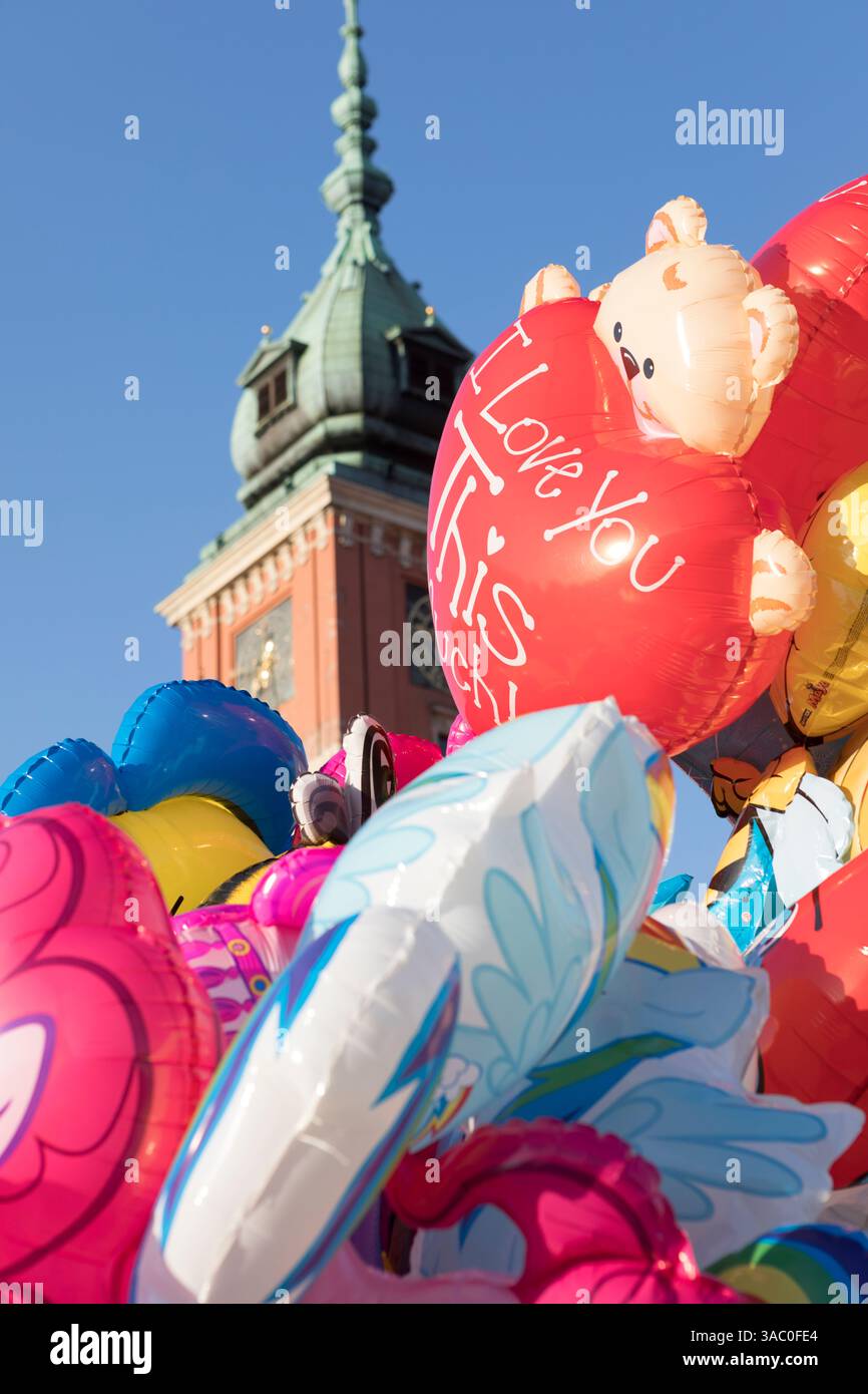 Poland, Warsaw, tourist balloons for sale and the clock tower of the ...