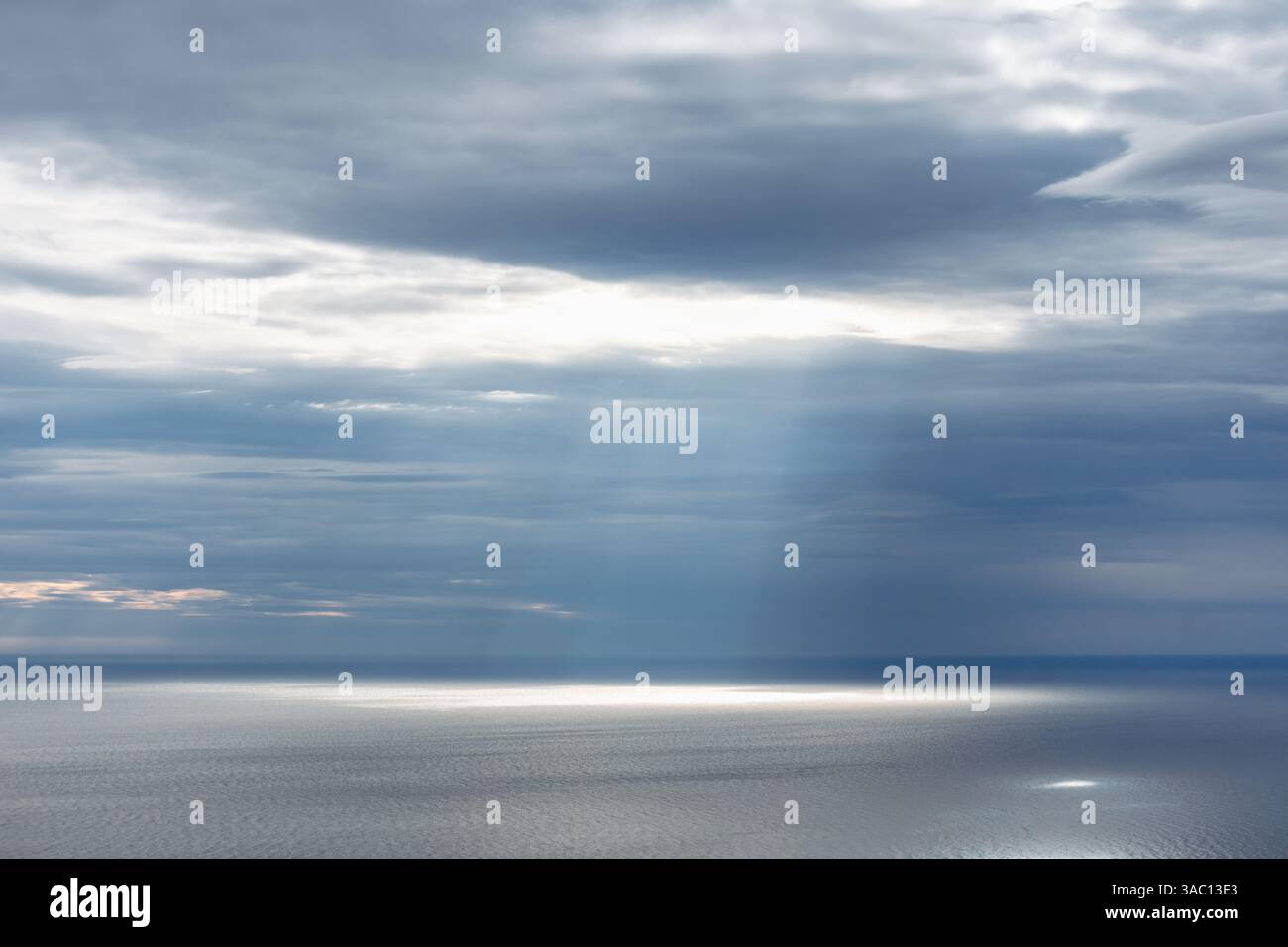 Sun rays breaking through the clouds and falling on the Mediterranean ...