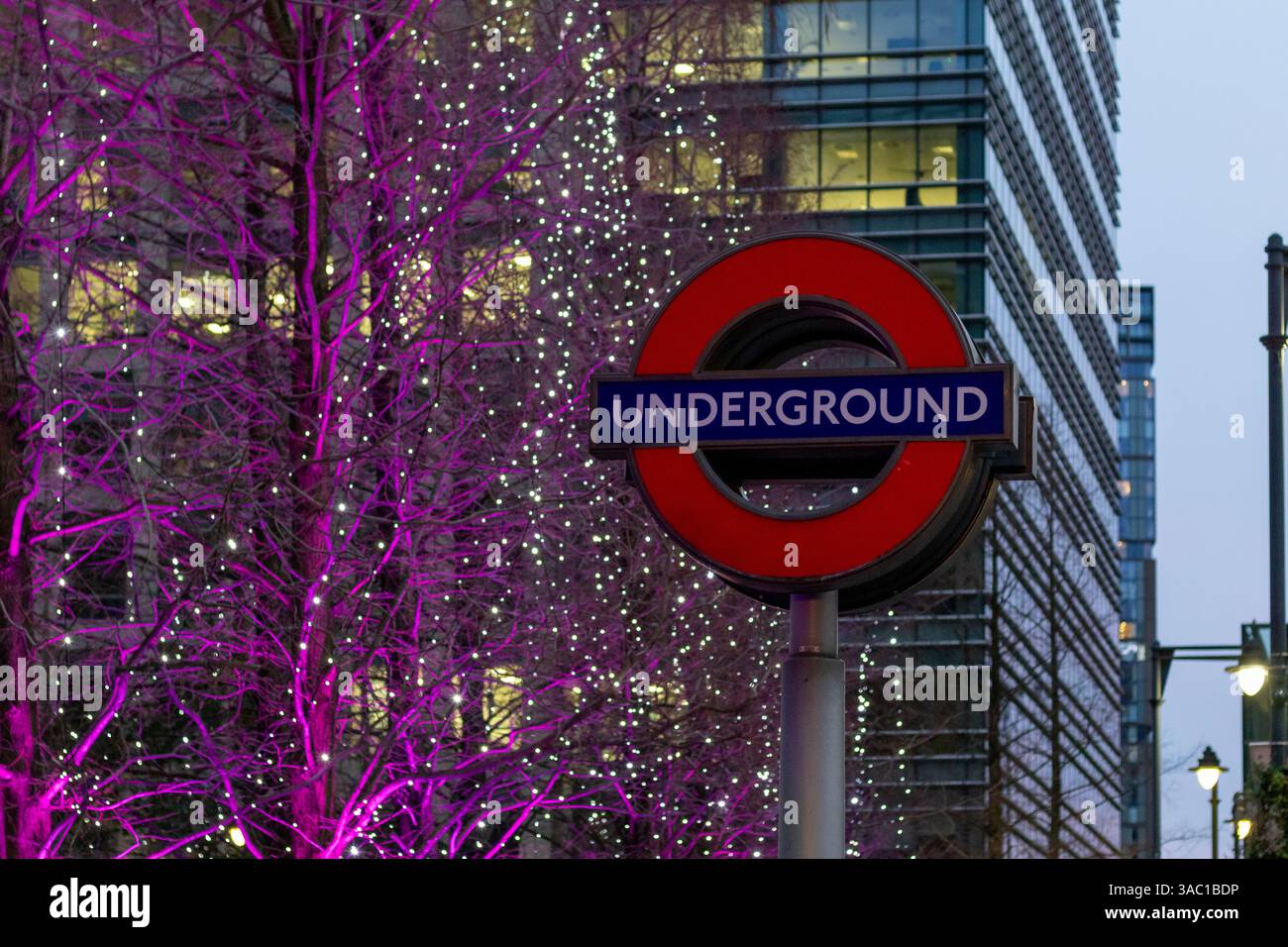 The underground sign for the tube line at night - Tube Station entrance ...