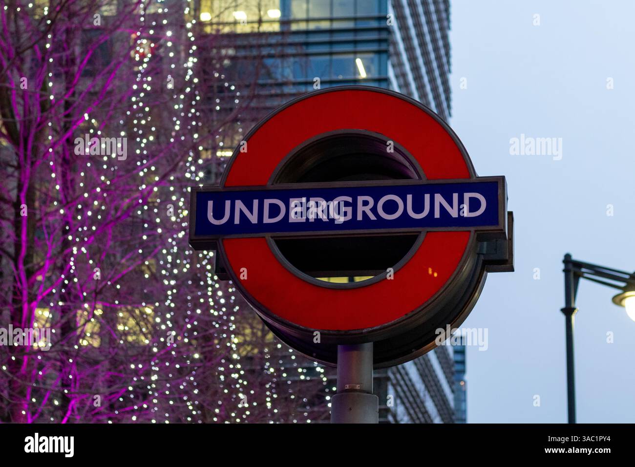 The underground sign for the tube line at night - Tube Station entrance ...