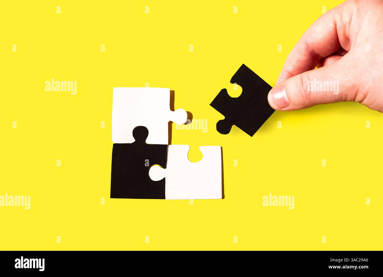 Hand trying to finish puzzle connecting the last piece of puzzle ...