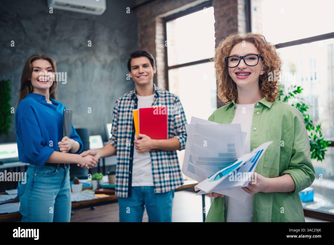 Three young professionals collaborate in a modern office environment ...