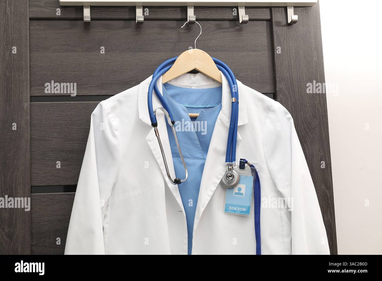 Doctor's coat with stethoscope and badge on hanger indoors Stock Photo ...