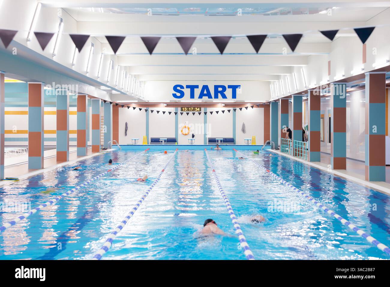 People swimming in indoor pool with clean water and lane dividers Stock ...