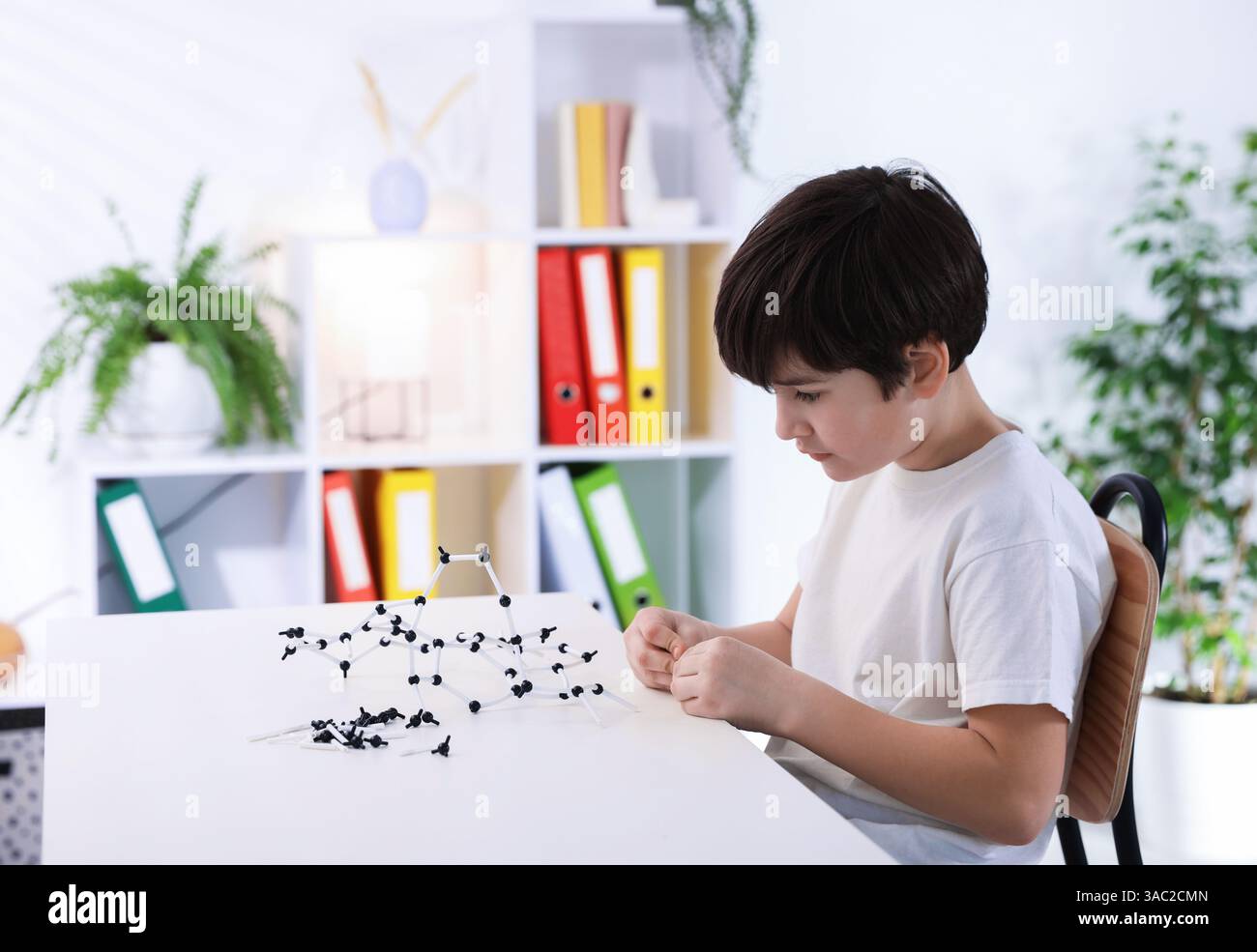 Boy making DNA structure model at desk indoors. Space for text Stock ...