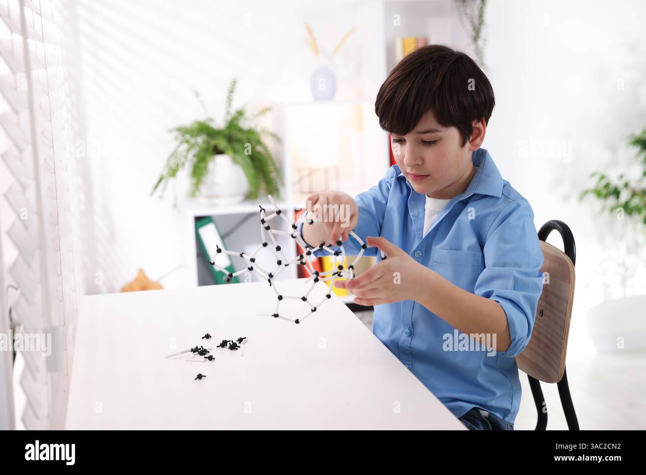 Boy making DNA structure model at desk indoors. Space for text Stock ...