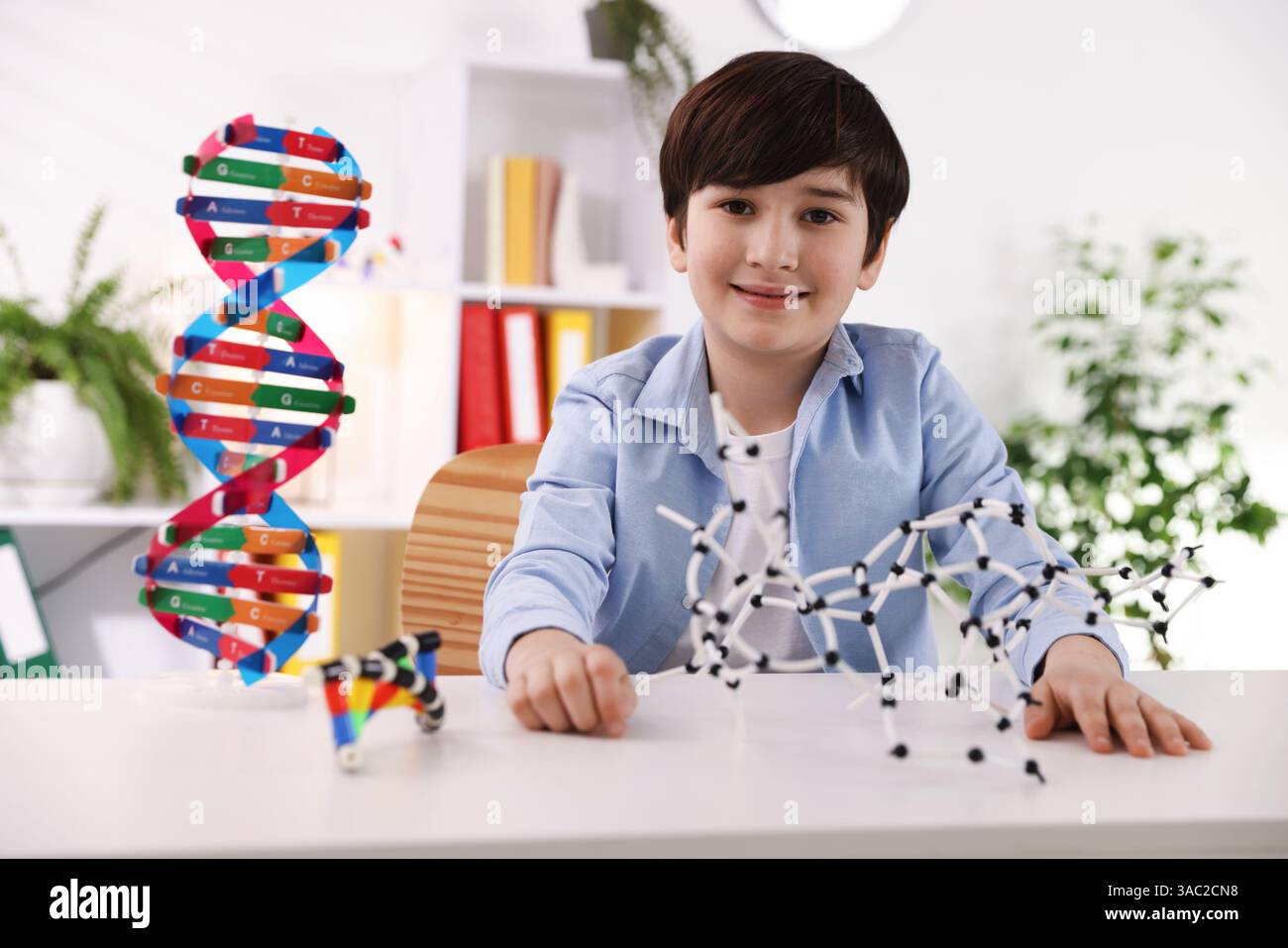 Boy with DNA structure model at desk indoors Stock Photo - Alamy