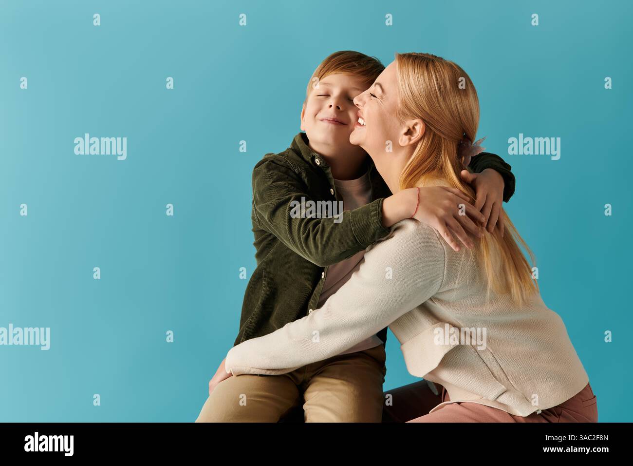 A mother and son share a warm embrace on a bright blue background ...