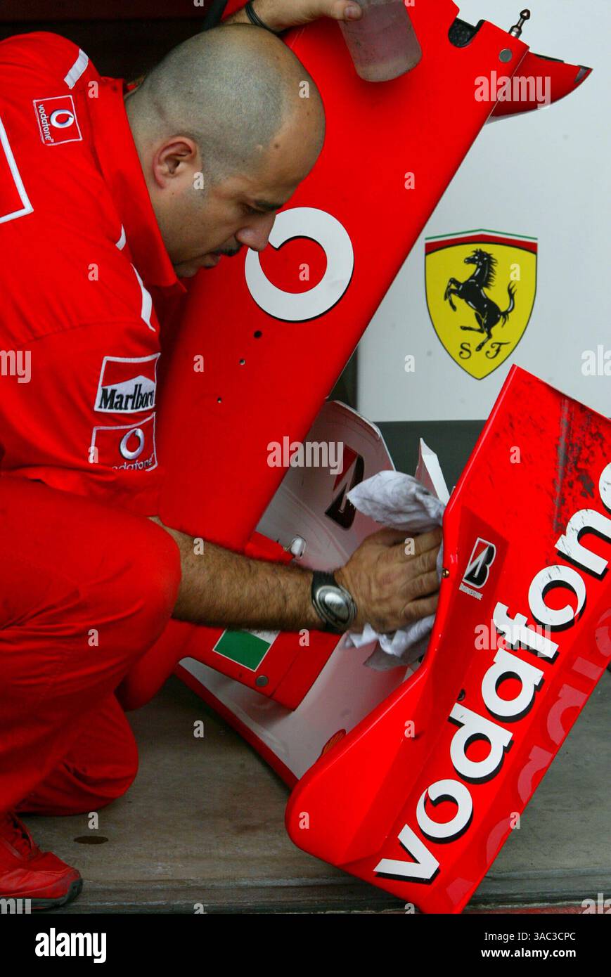A mechanic cleans the dirty front wing of Rubens Barrichello (BRA ...