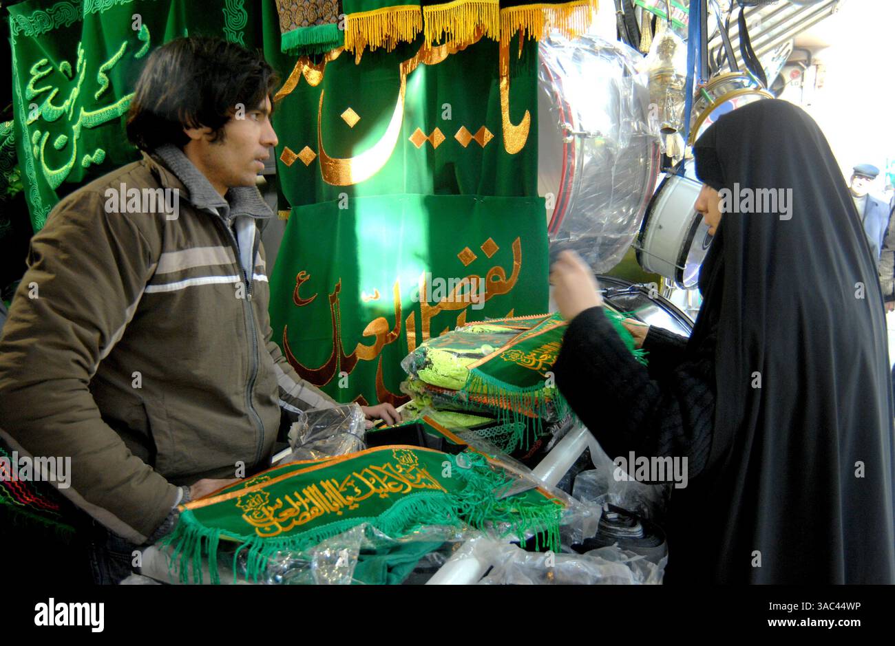 Jan 14, 2008 - Tehran, Iran - An Iranian woman buys an islamic flag for ...