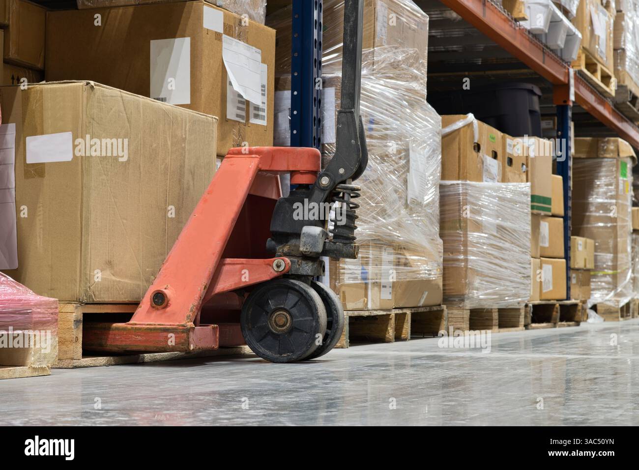 Pallet jack under wooden pallet stock ground level industrial warehouse ...