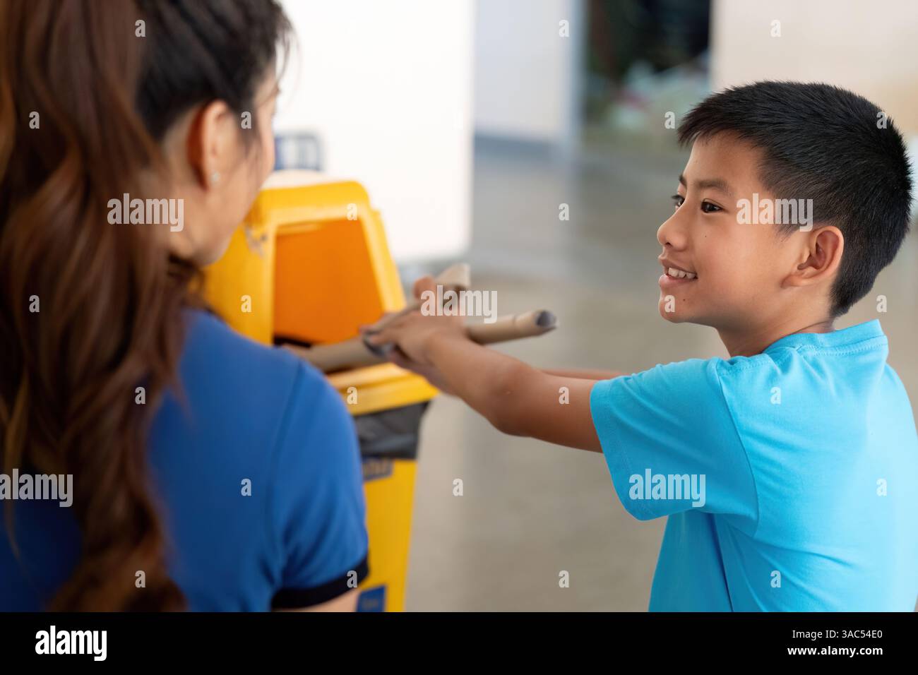 Engaging Youth in Recycling. A boy and a woman enthusiastically ...