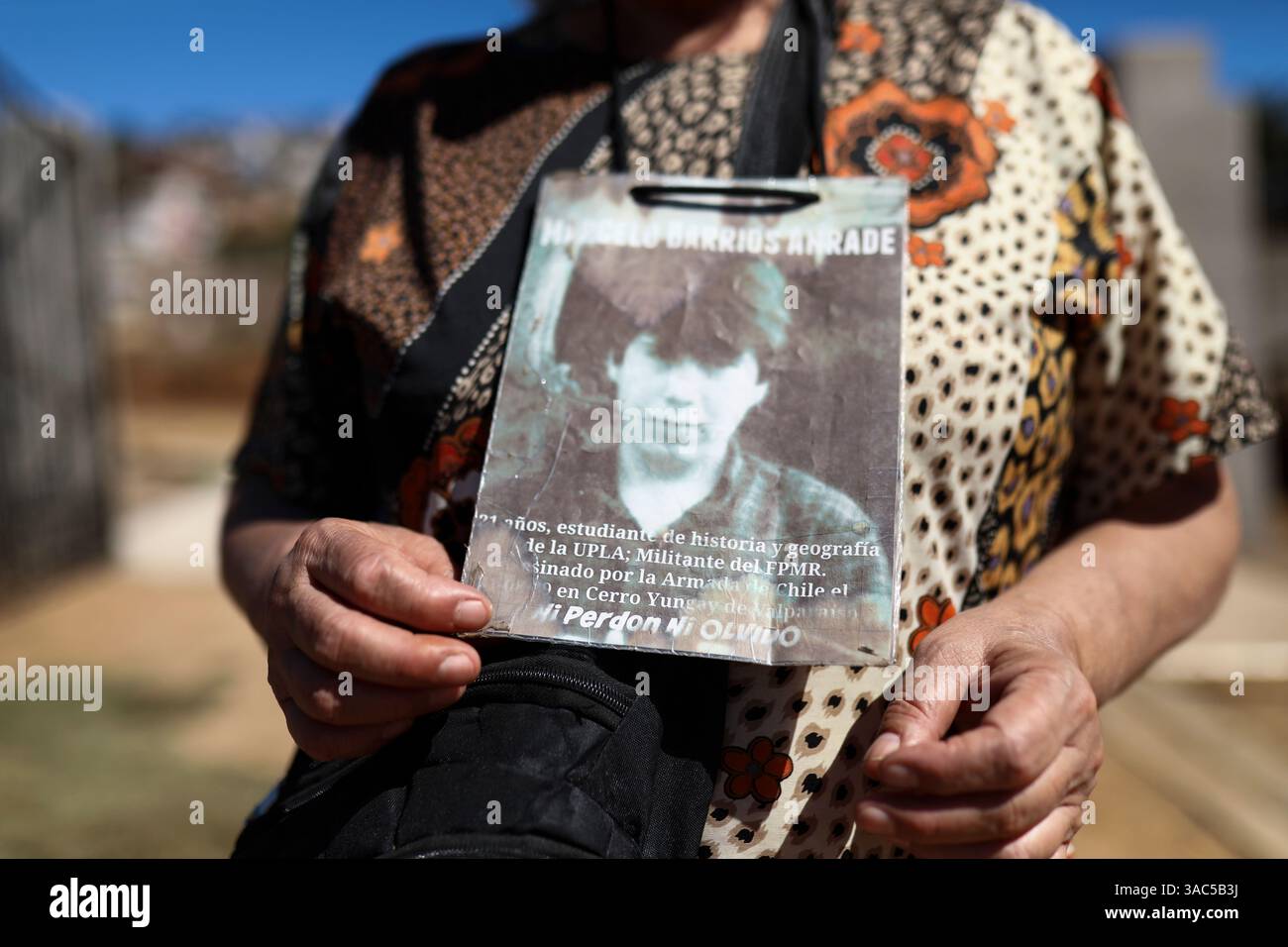 A woman holds a photograph of her brother, who was detained and ...