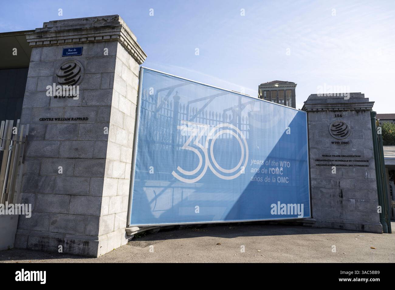 A giant sign hanging in front of the WTO reading 30 years of the WTO or ...