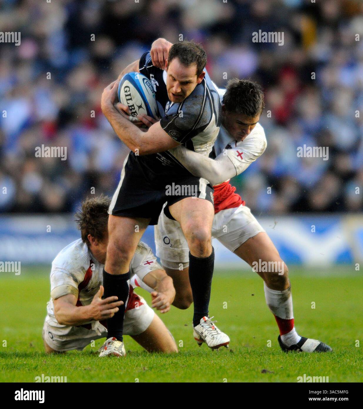 Scotland's Graeme Morrison (C) stands strong in the tackles from ...