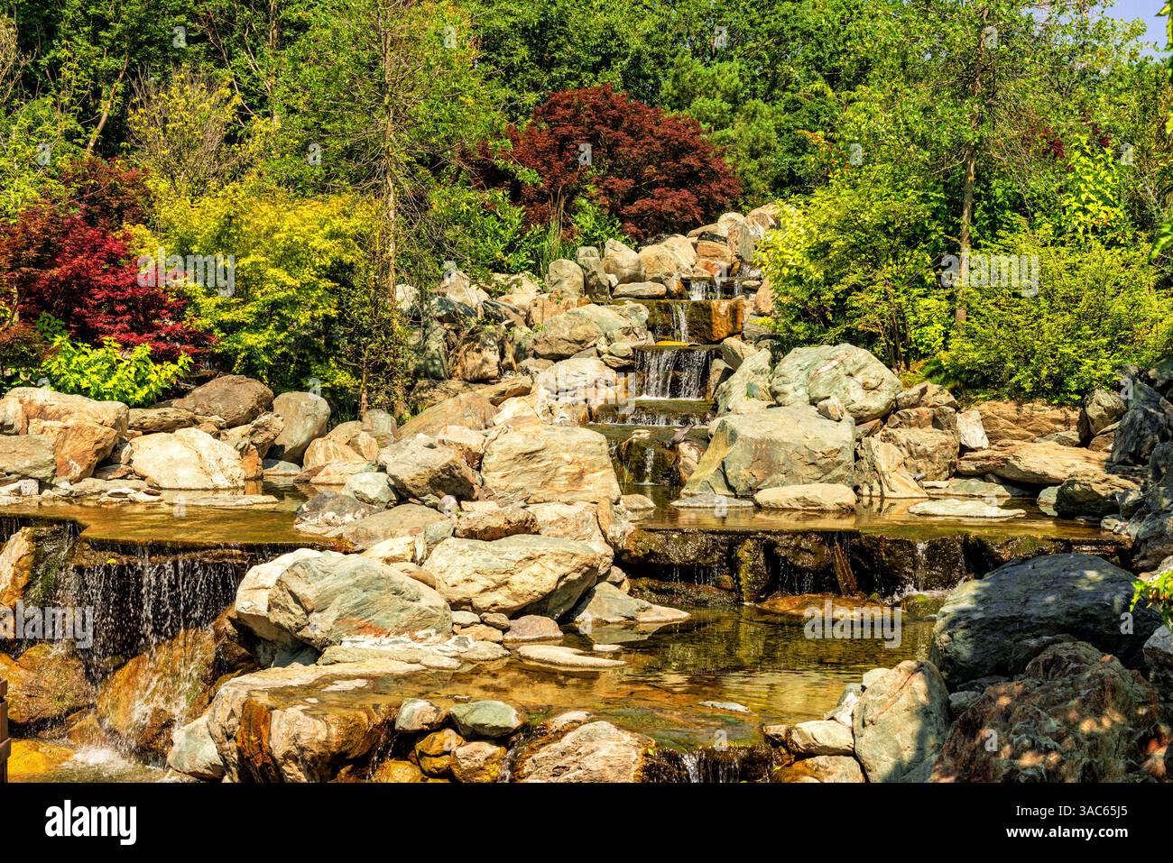 Multi-stage decorative waterfall on a stream in a public park Stock ...