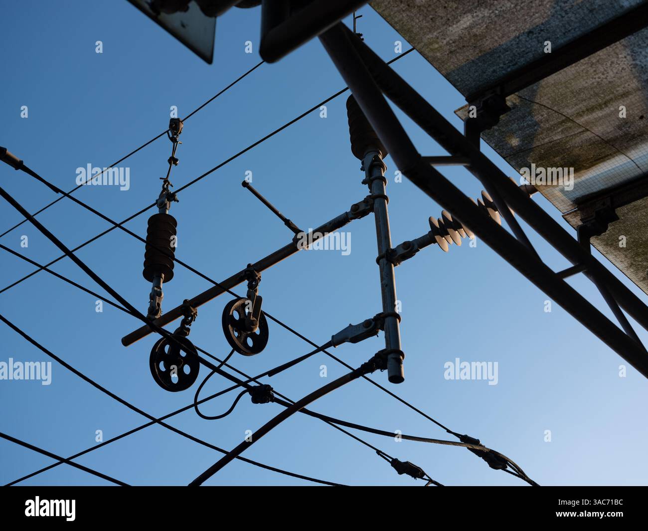 A view of overhead power cables and insulators that power the railway ...