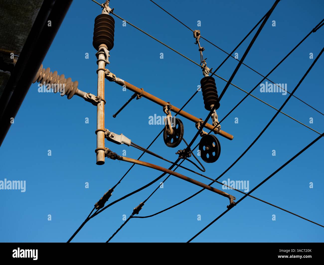 A view of overhead power cables and insulators that power the railway ...