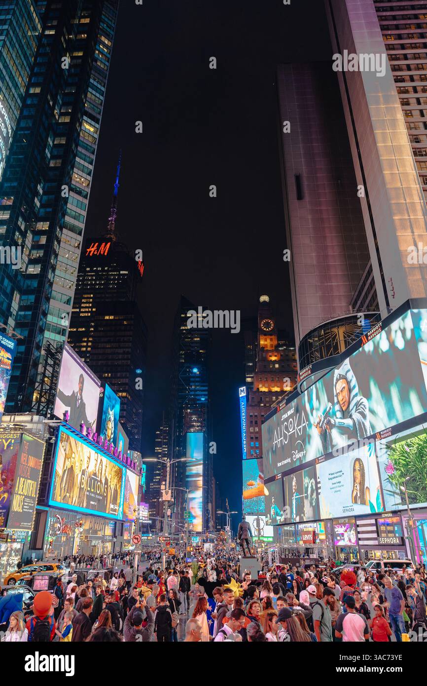 A crowd of people standing, walking, and talking at Times Square at ...