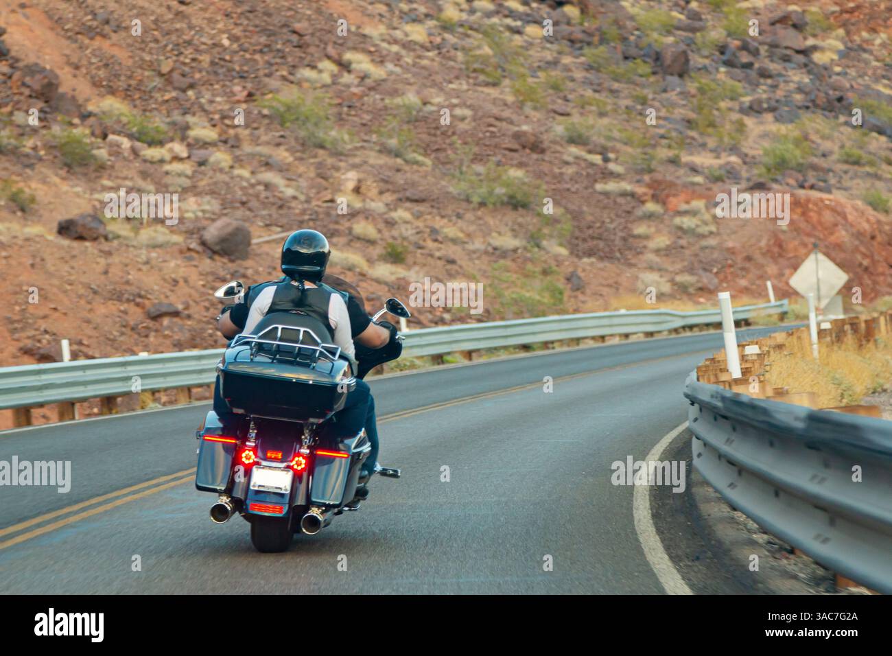 Biker couple riding chopper through mountain road. Male and female ...