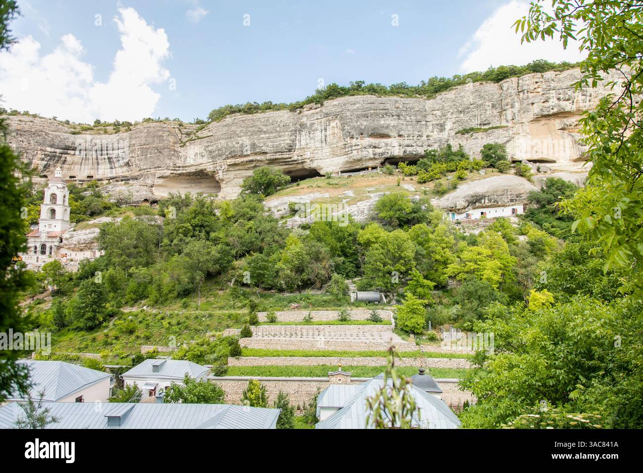 A sweeping panoramic view reveals a cliffside cave monastery nestled in ...
