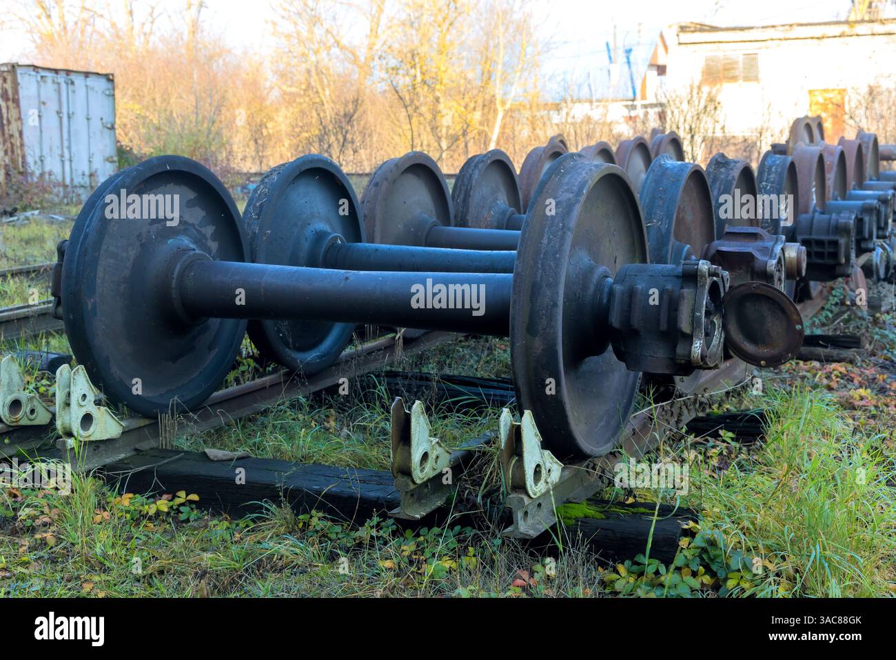 Old train wheels rest on supports in deserted yard, awaiting inspection ...