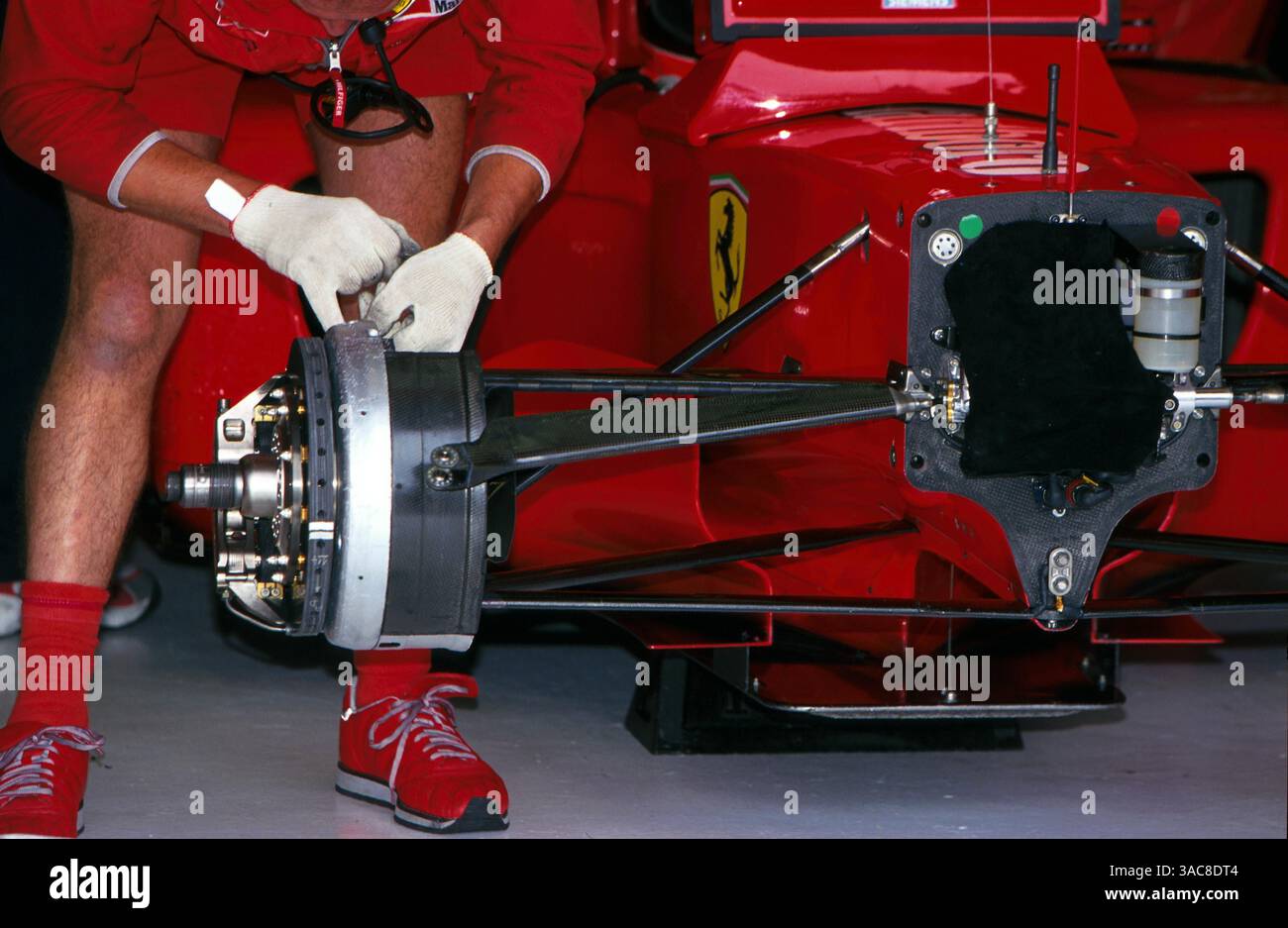 A Ferrari mechanic works on the unique drum braking system on the F2001 ...