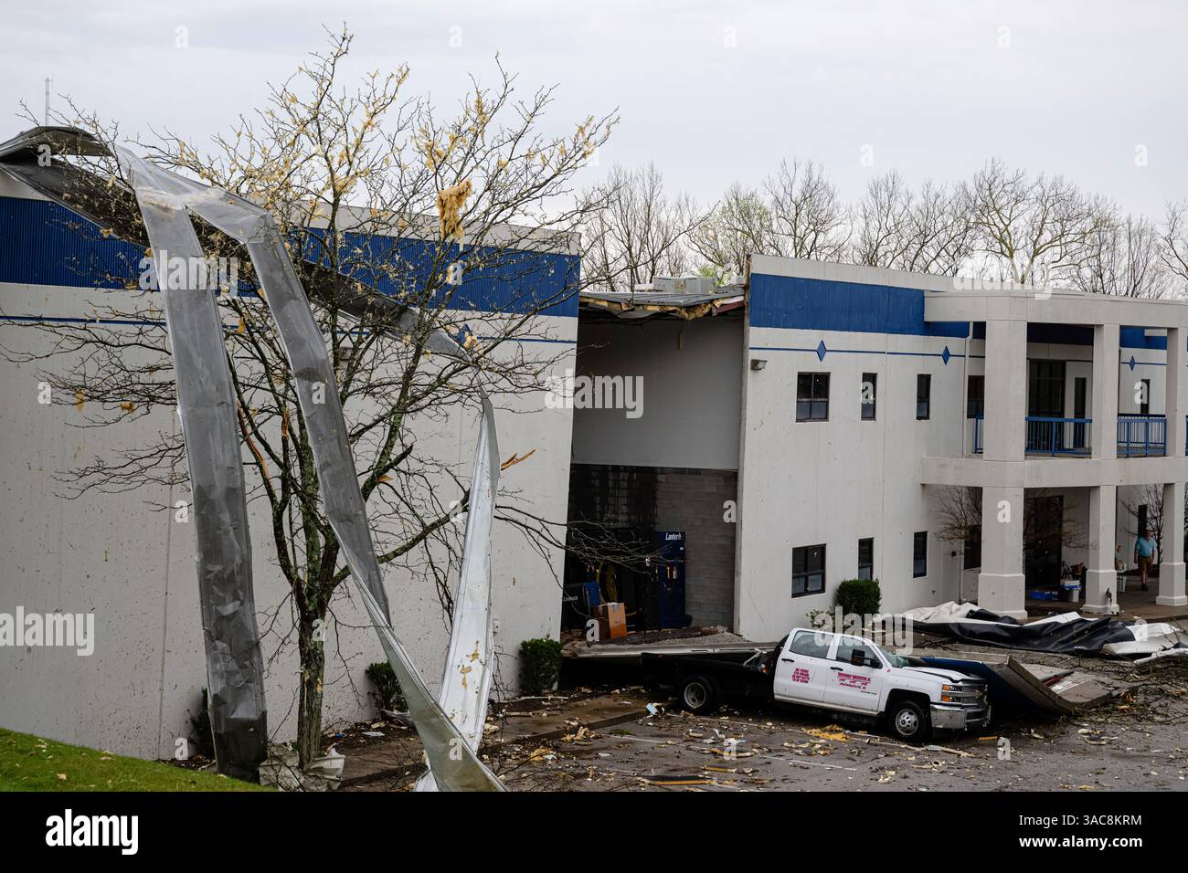 A smashed truck sits under a section of collapsed warehouse wall after ...