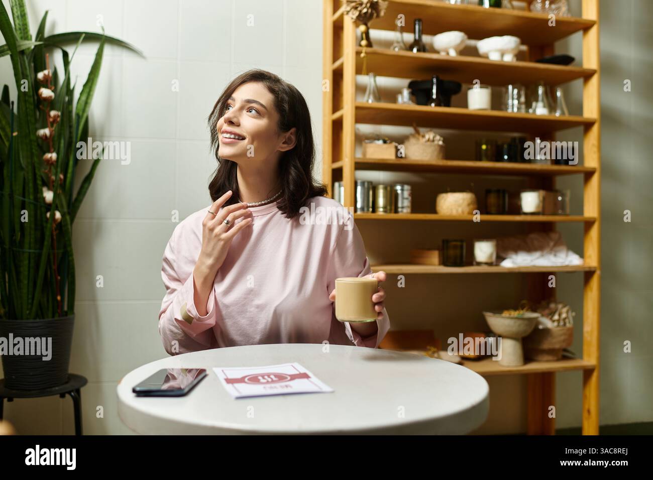 A pretty young woman sips her coffee, enjoying a quiet moment in a ...