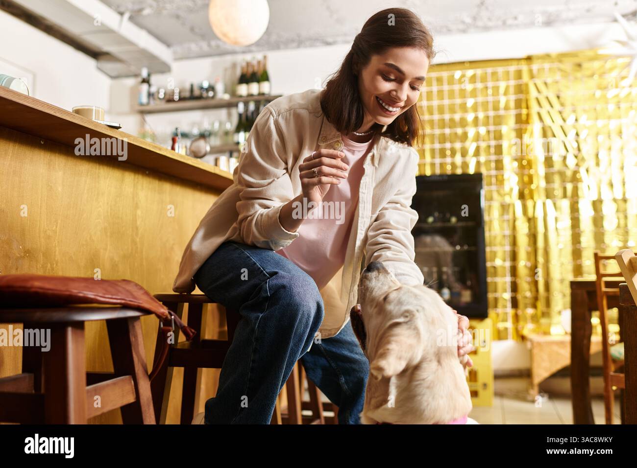 A young woman enjoys time with her labrador at a modern cafe designed ...