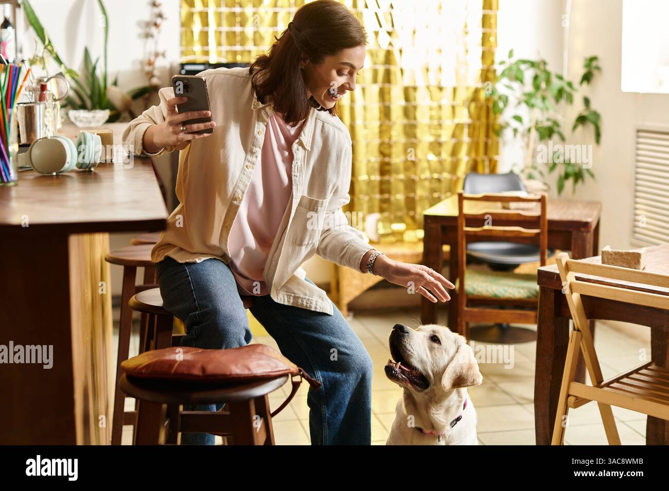 A cheerful young woman shares a moment with her labrador in a vibrant ...