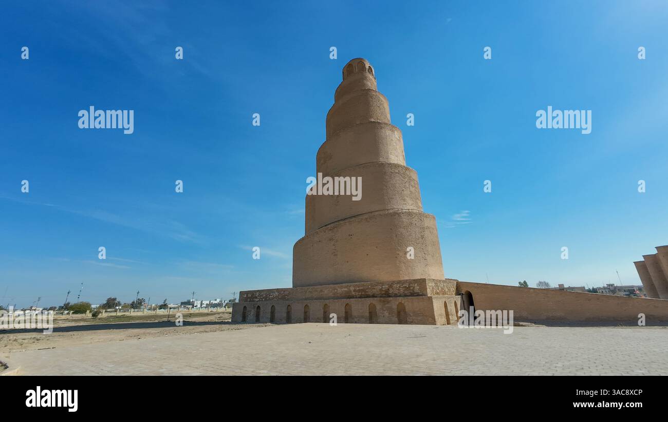 A large, spiral minaret with a unique conical shape stands under a ...