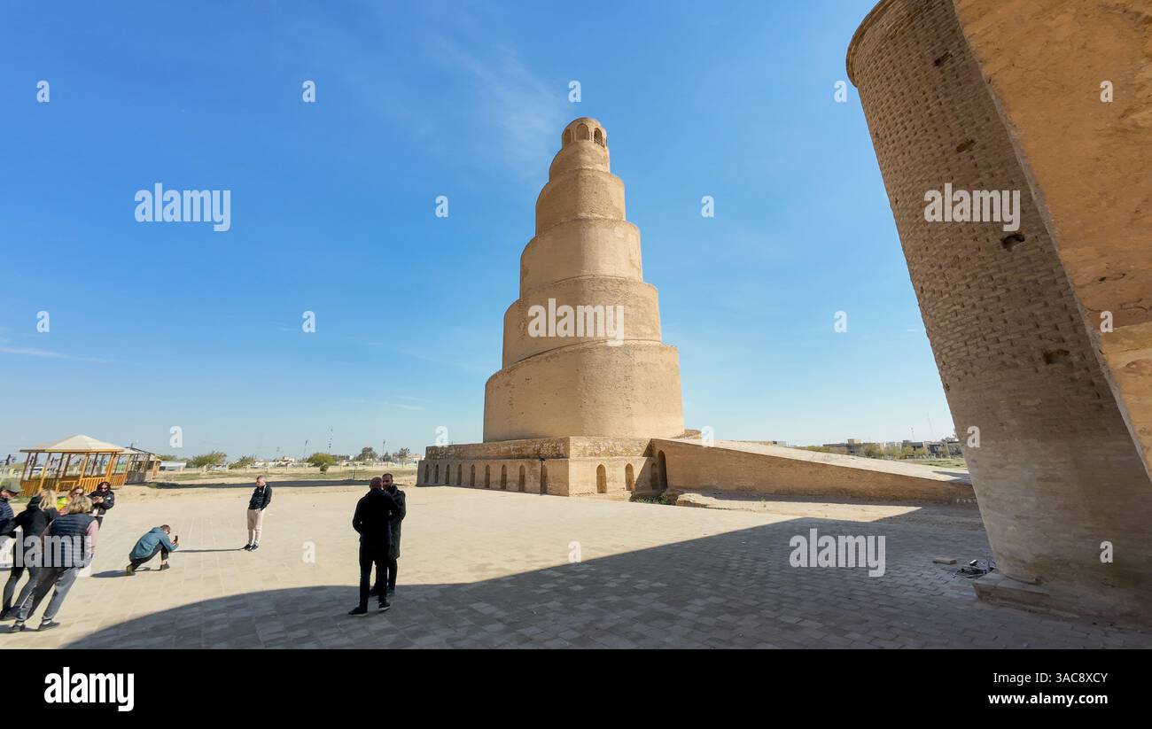 A group of tourists visit the iconic spiral minaret of the Great Mosque ...