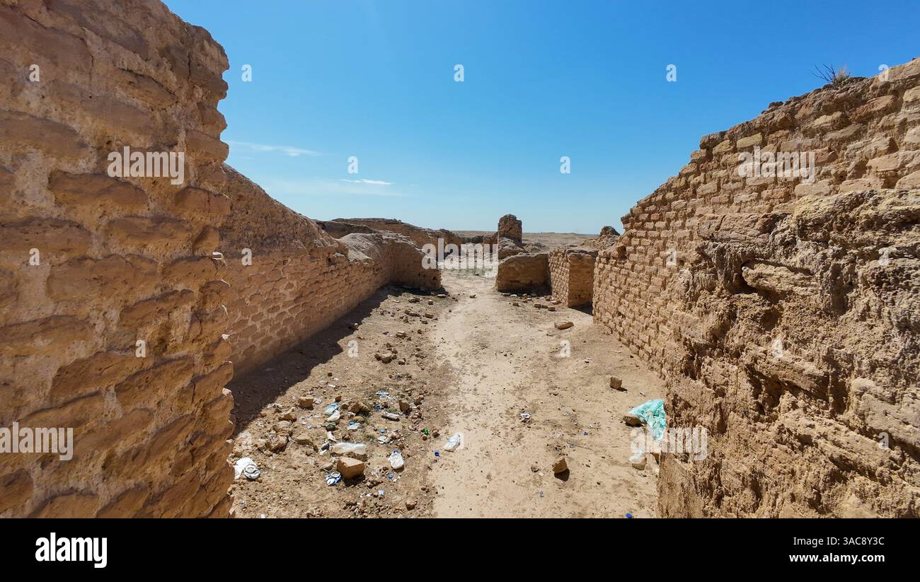 A deserted ancient ruin with crumbling brick walls under a clear blue ...