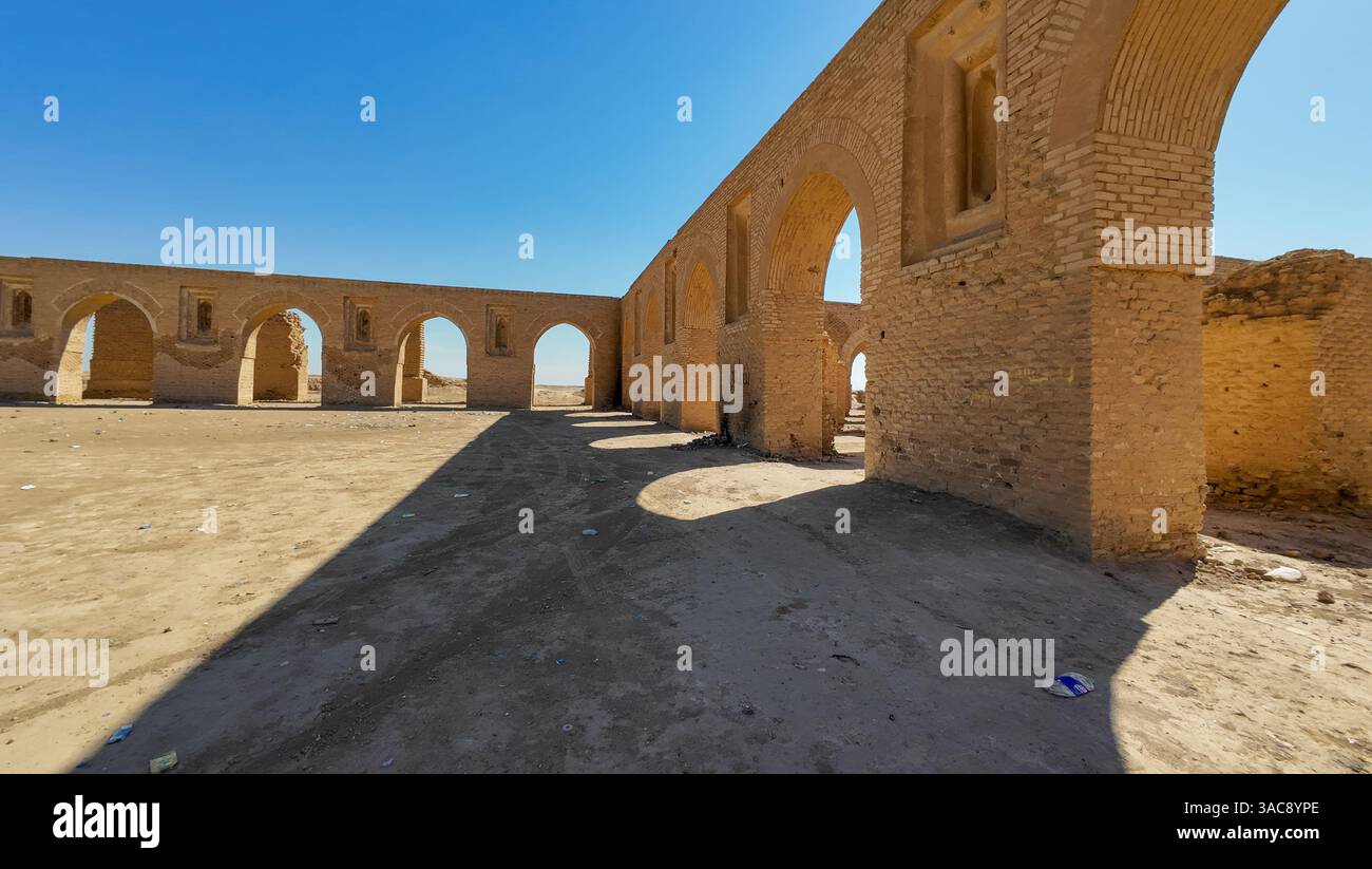 Ancient brick ruins with arches under a clear blue sky in a desert ...