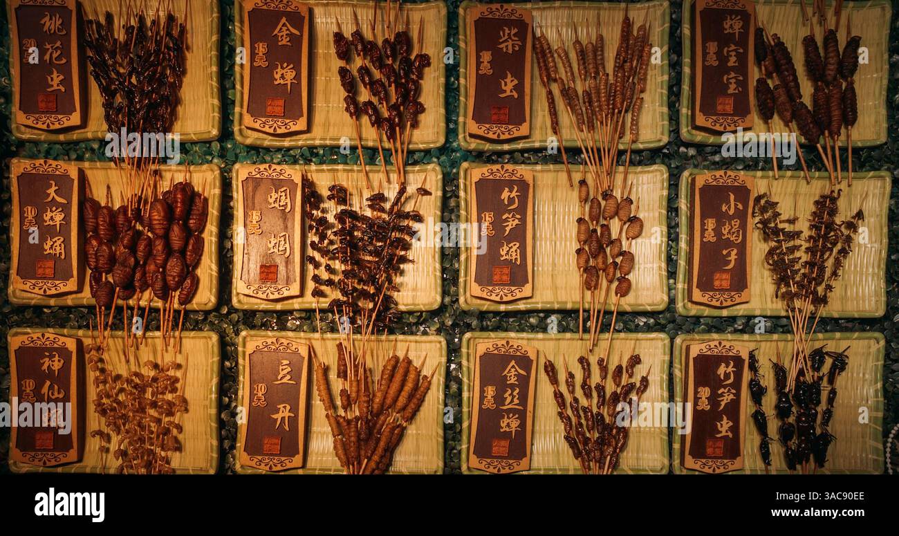 Chengdu, Sichuan, China. Insects on sticks at local Chinese market ...
