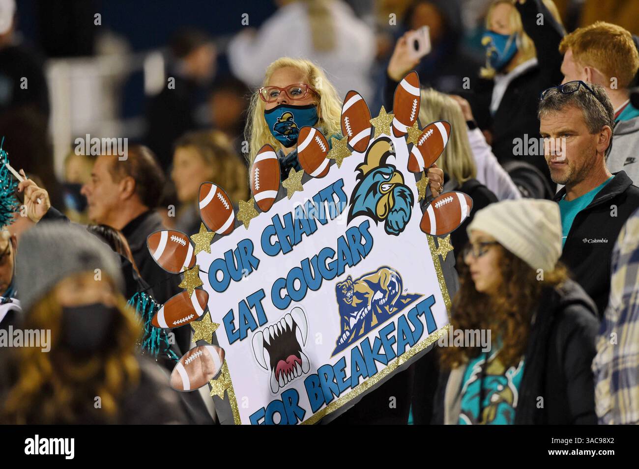 A Coastal Carolina fan holds a sign and cheers during the first half of ...