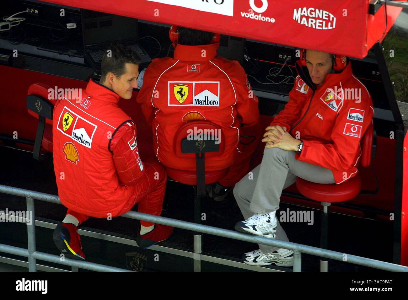 Michael Schumacher(GER) and Luciano Burti(BRA) sit on the pit wall ...