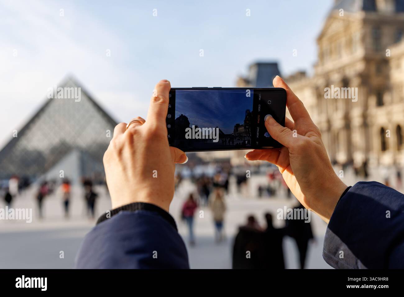 A person is capturing a photo of the iconic Eiffel Tower using their ...